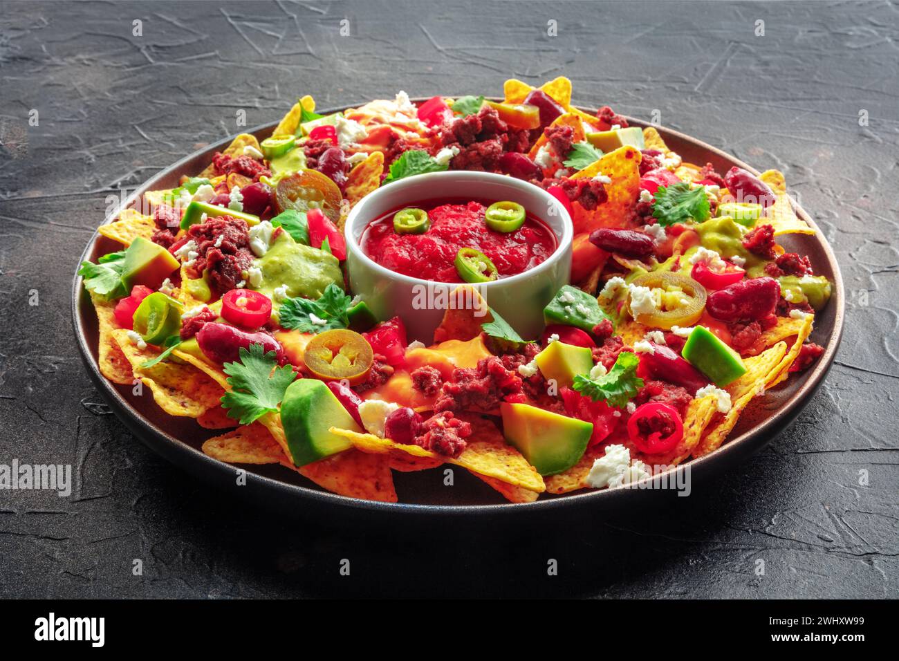 Loaded nachos. Mexican nacho chips with beef and avocado Stock Photo ...