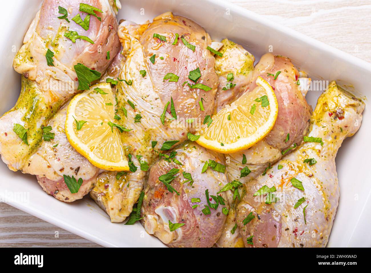 Raw uncooked chicken legs marinated with seasonings, herbs, lemon in ...