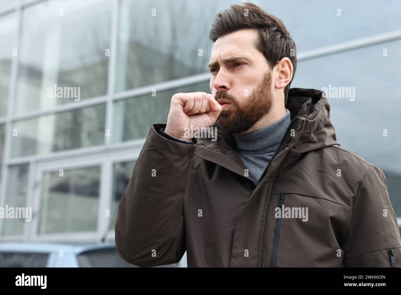 Sick man coughing on city street. Cold symptoms Stock Photo - Alamy