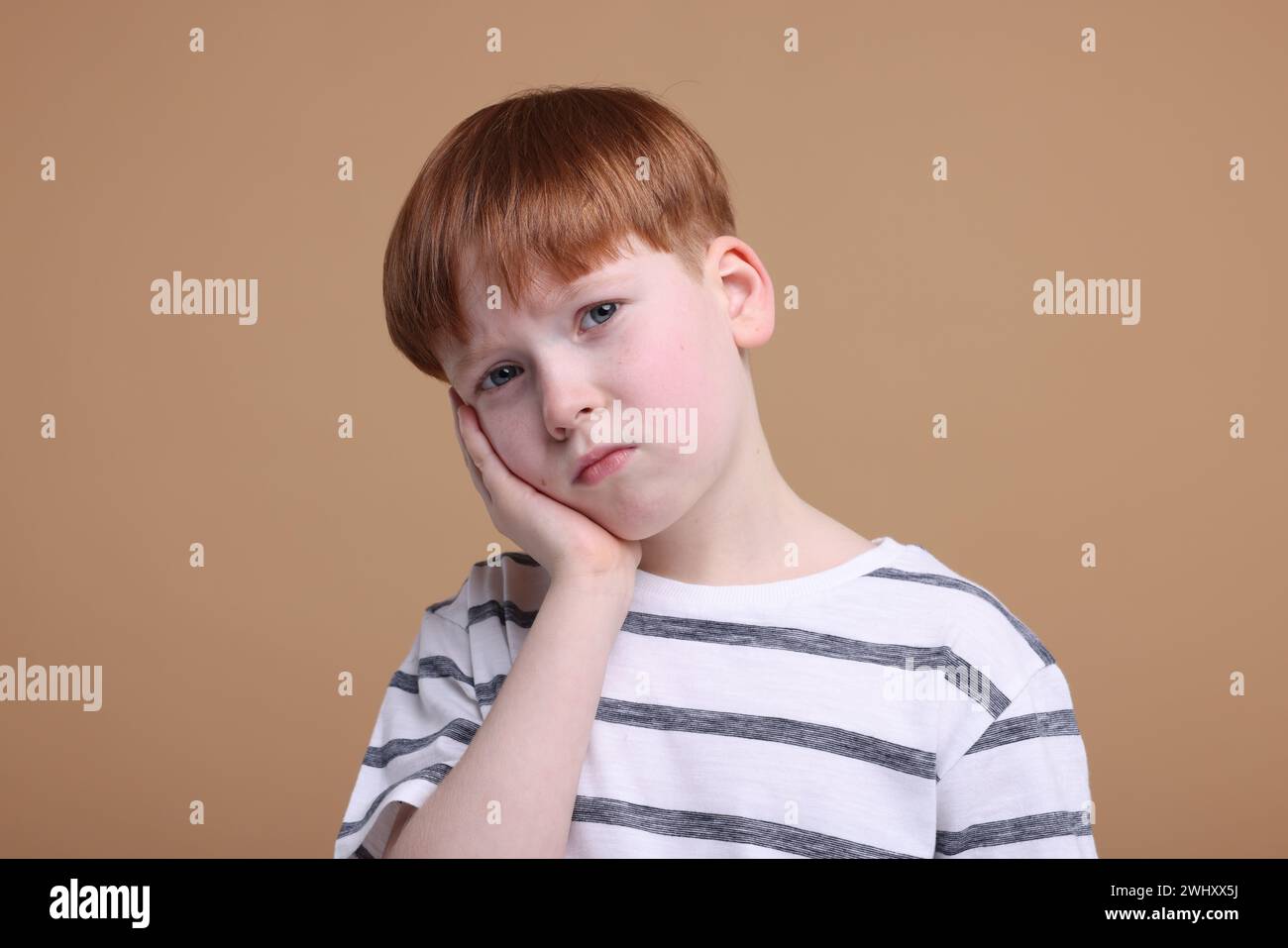 Portrait of sad little boy on beige background Stock Photo - Alamy