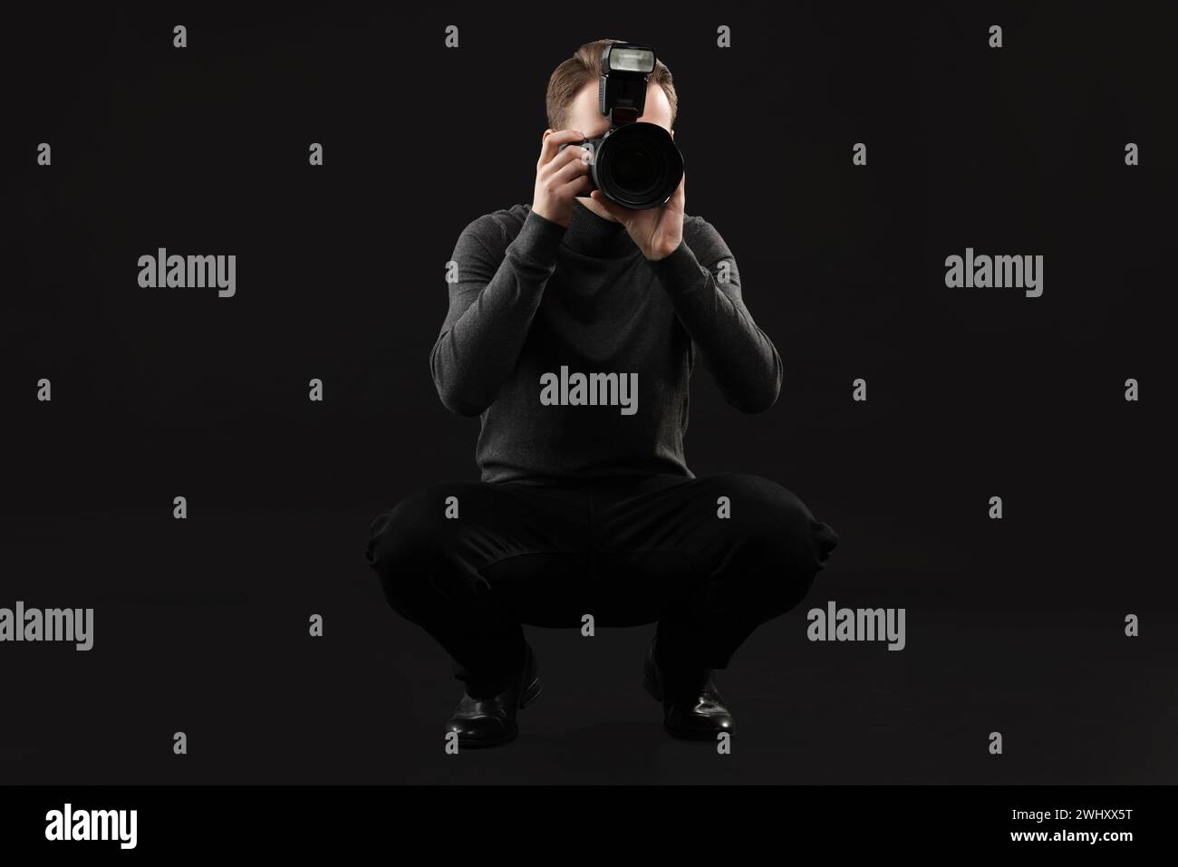 Professional photographer taking picture on black background Stock ...