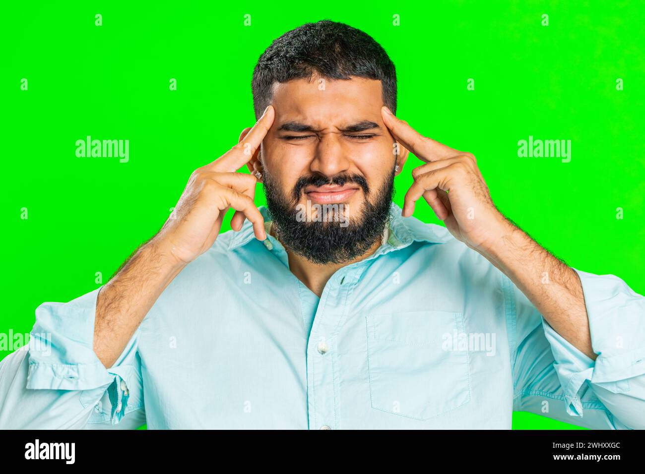 Displeased exhausted Indian man guy rubbing temples to cure headache ...