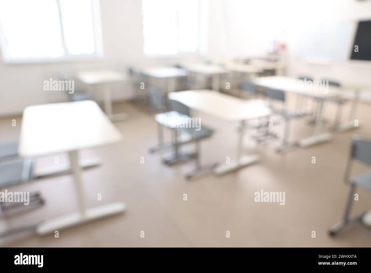 Blurred view of empty school classroom with desks and chairs Stock ...
