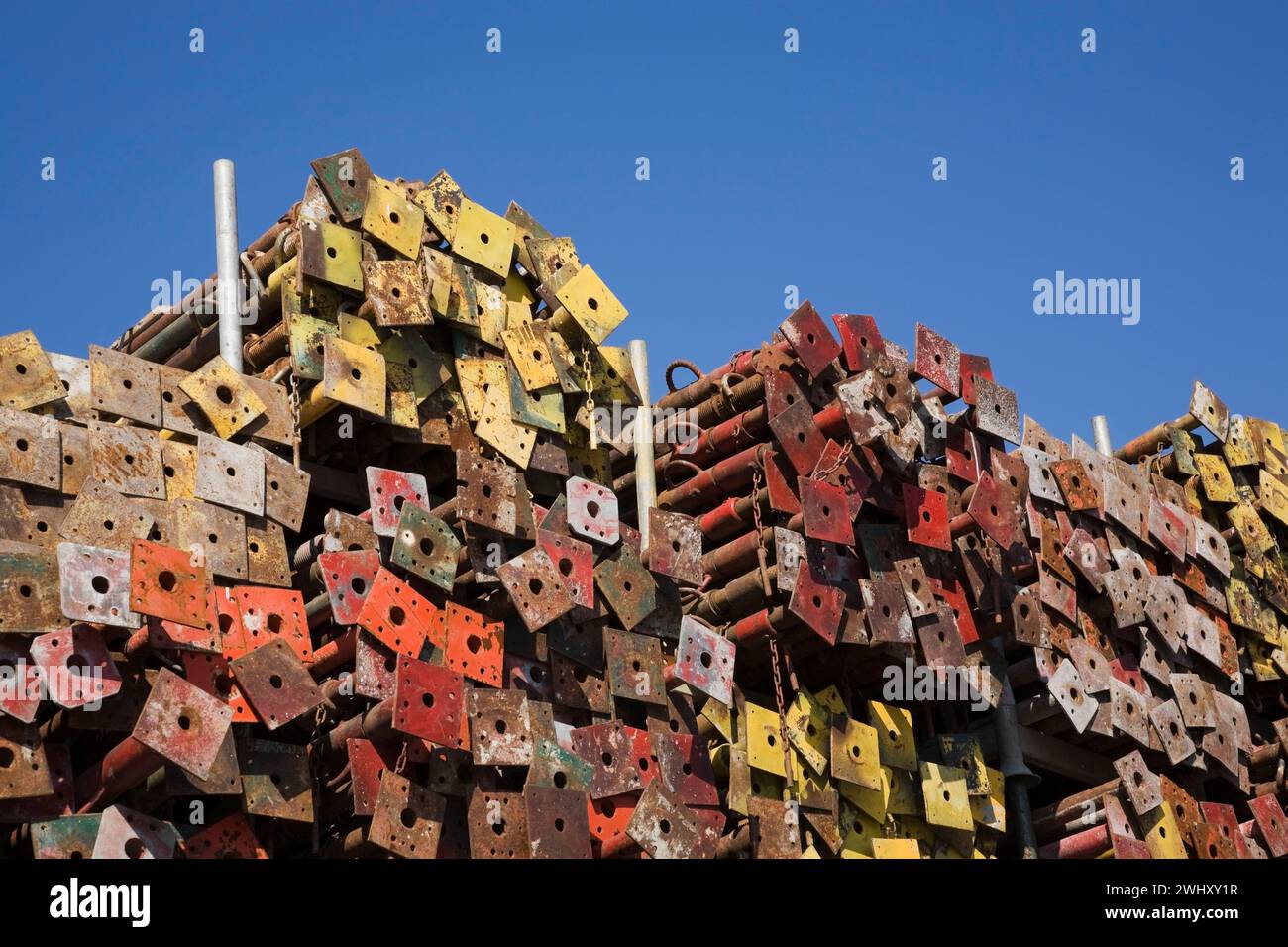 Pile of assorted colored steel jack posts with base plates in outdoor ...