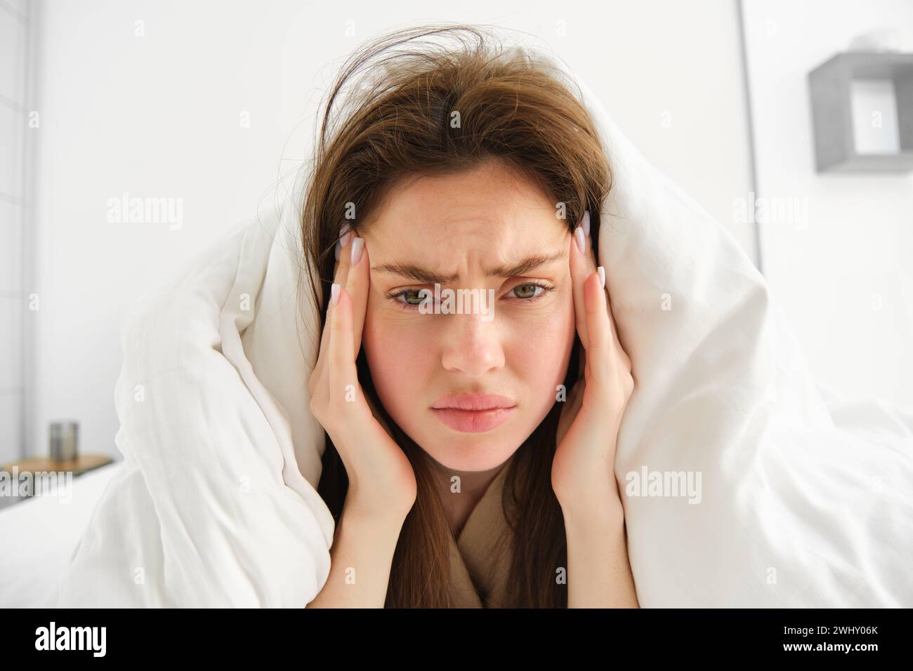 Woman feeling unwell in bed, lying in her bedroom under blanket and ...