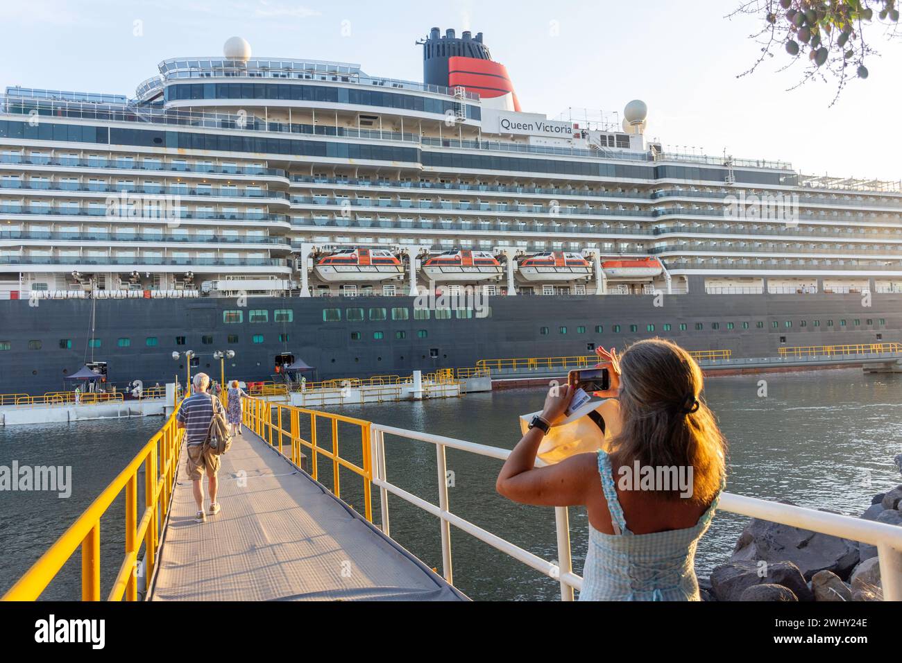 Passengers reboarding Cunard Queen Victoria cruise ship at tourist ...