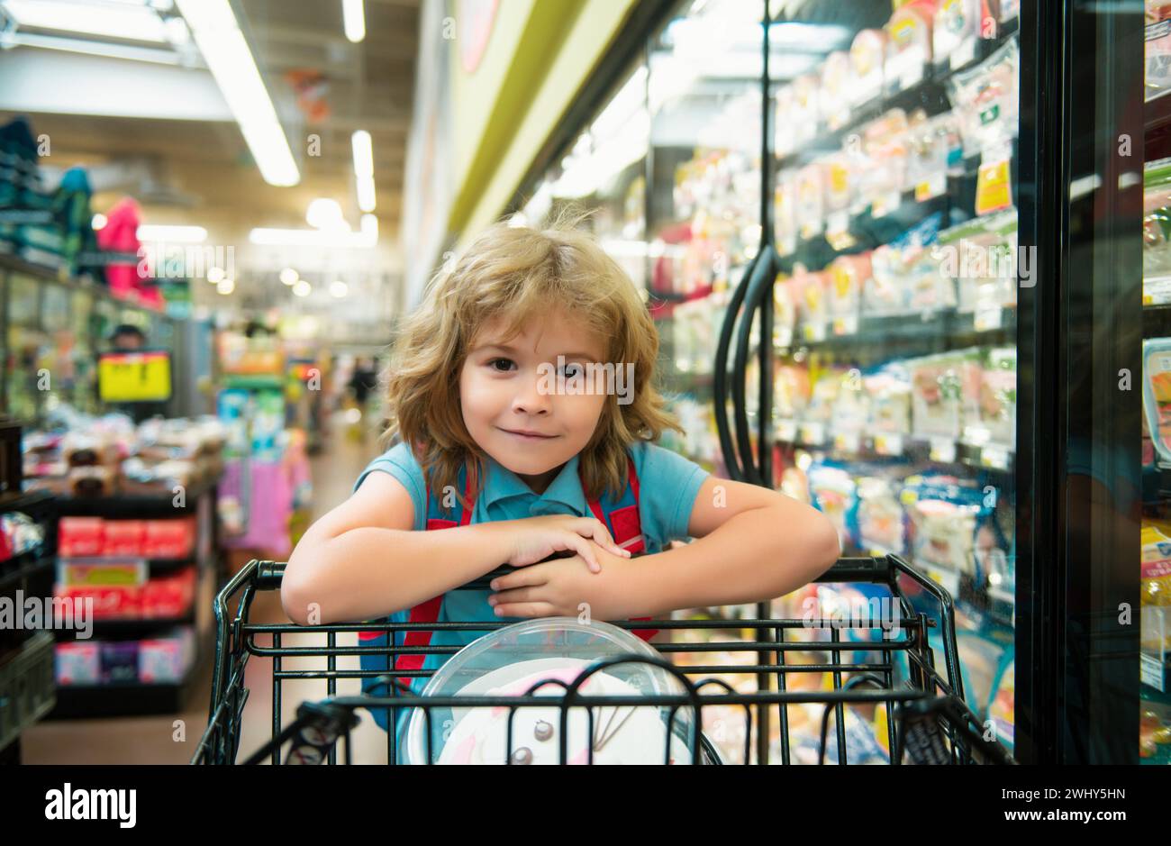 Little customer child at grocery or supermarket with goods in shopping ...