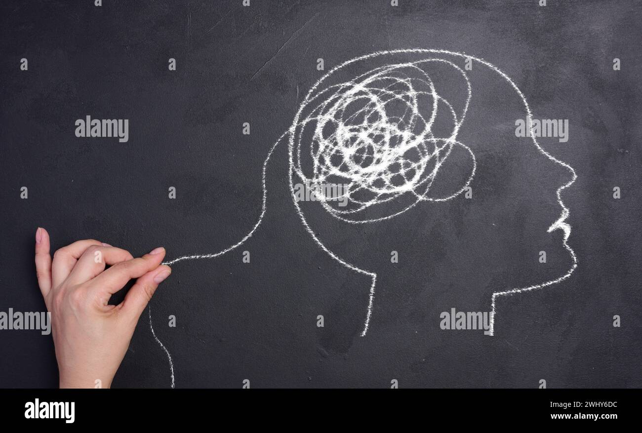 Profile of a human head with a tangled spiral in the brain area. The ...