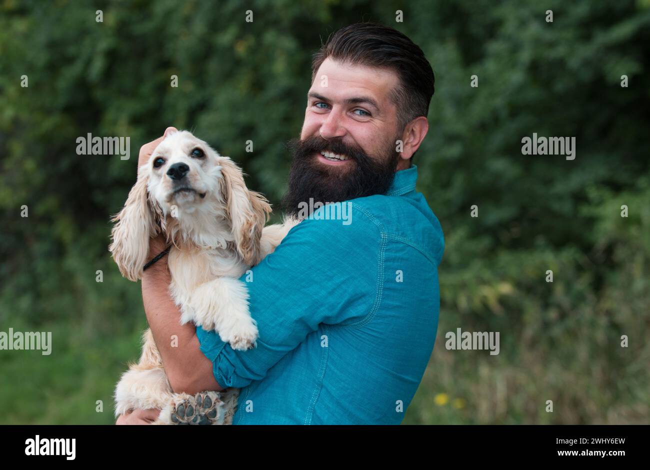 Cynologist concept. Man with Cocker Spaniel in dog park outdoors. Man ...