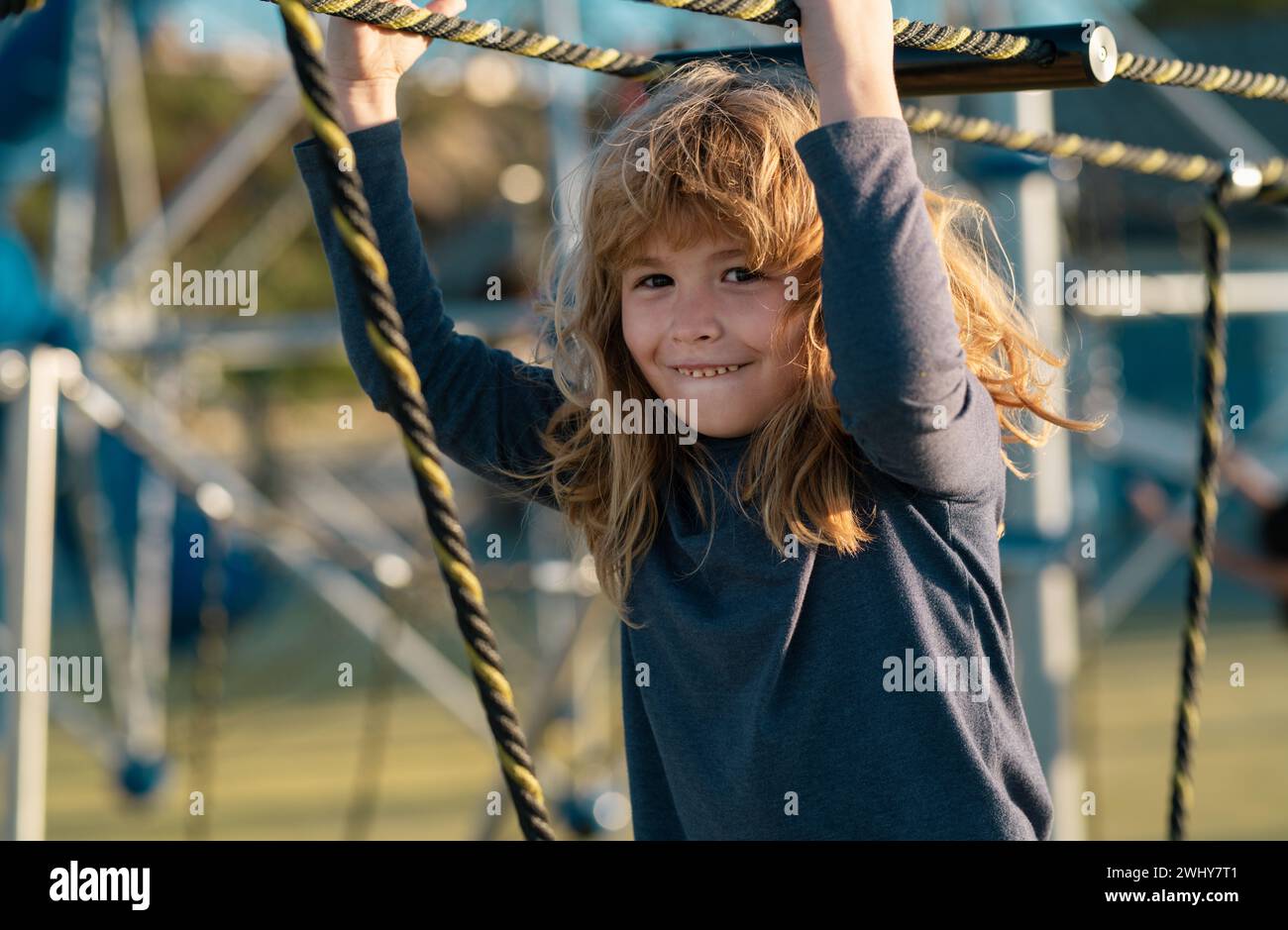 Kid boy climbing the net. Child playing on outdoor playground. Kids ...