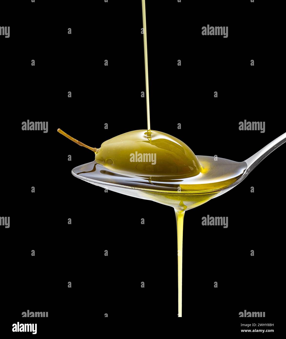 Green olive in full oil spoon on black isolated Stock Photo - Alamy