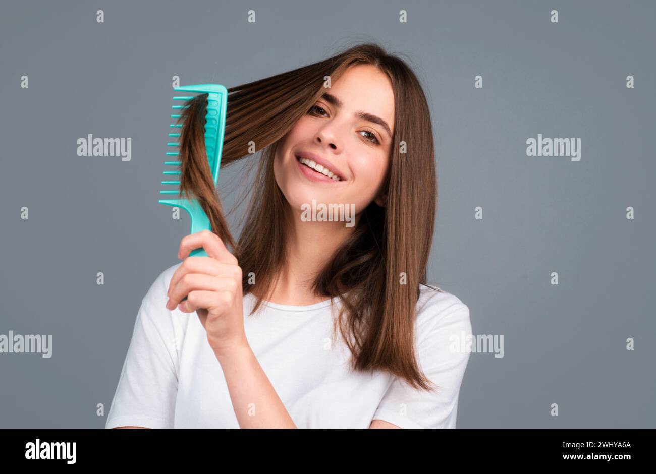 Beautiful woman combs her healthy hair. Combing healthy long straight ...
