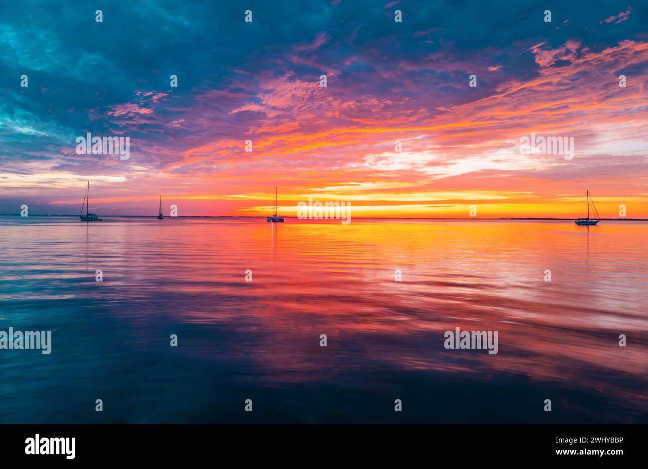 Calm sea with sunset sky and sun through the clouds over. Ocean and sky ...