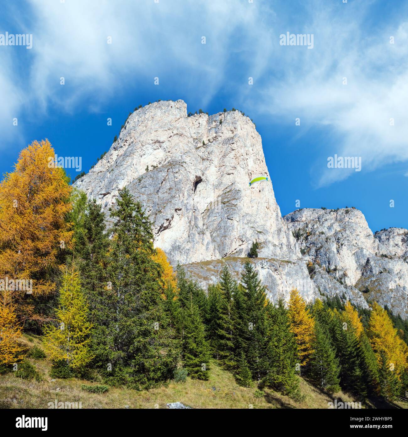 Autumn alpine Dolomites mountain scene and unrecognizable paragliders ...