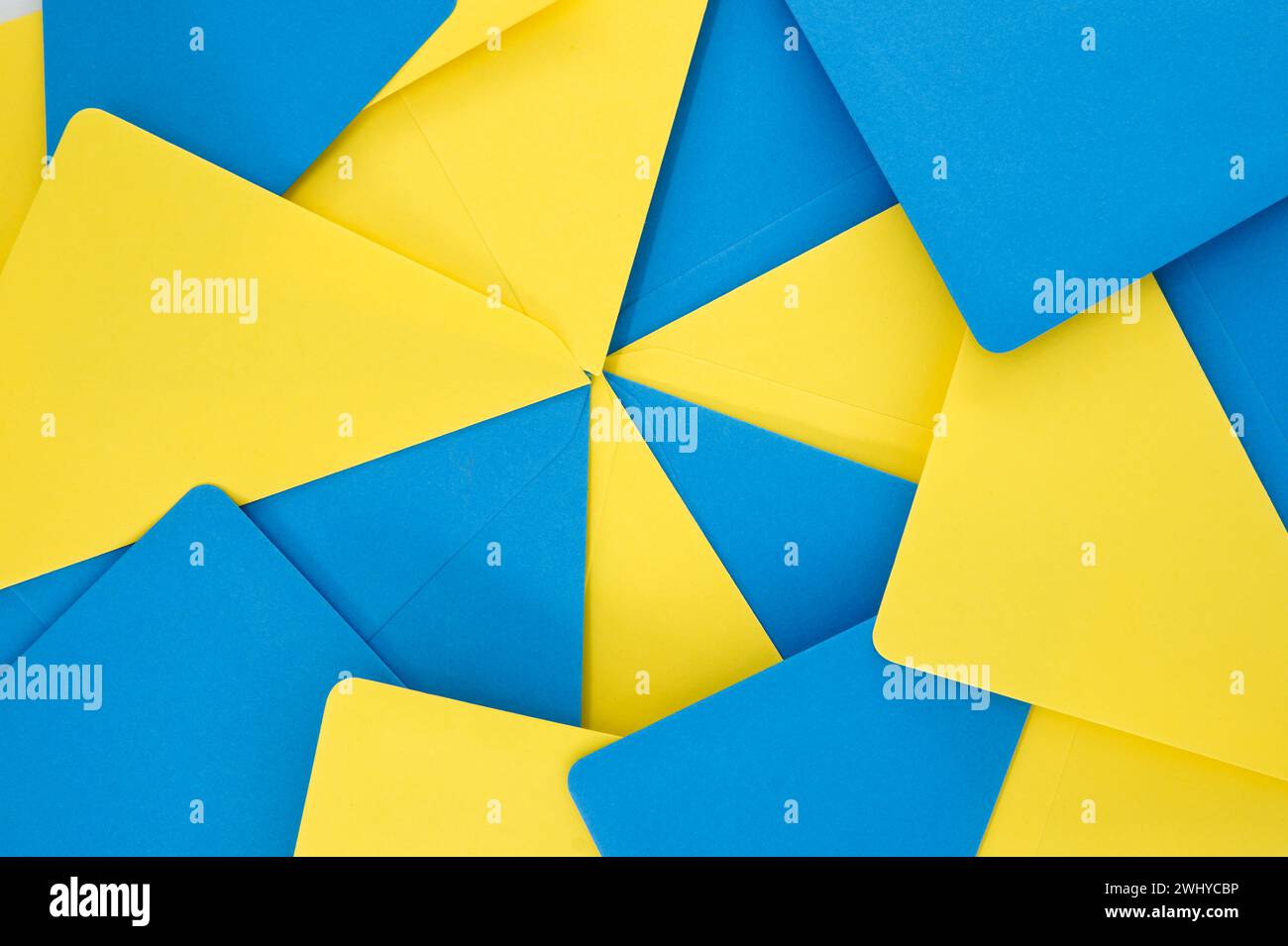 Blue and yellow paper envelopes organized in a symmetrical pattern ...