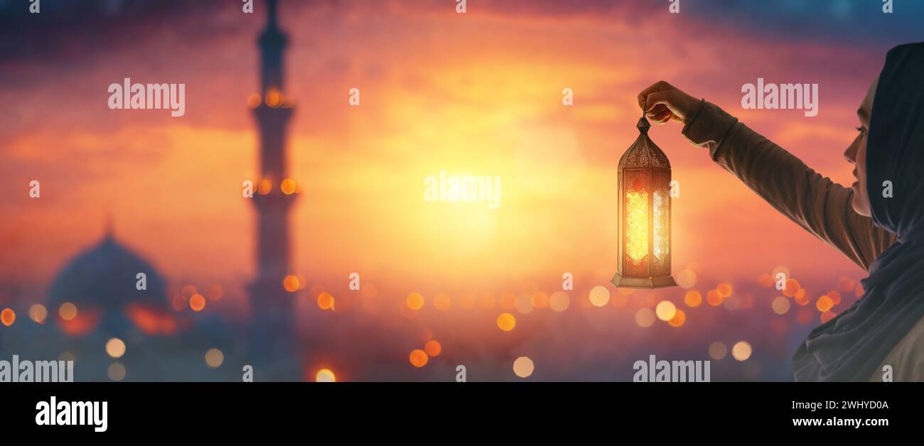 Woman is holding Ornamental Arabic lantern with burning candle glowing ...