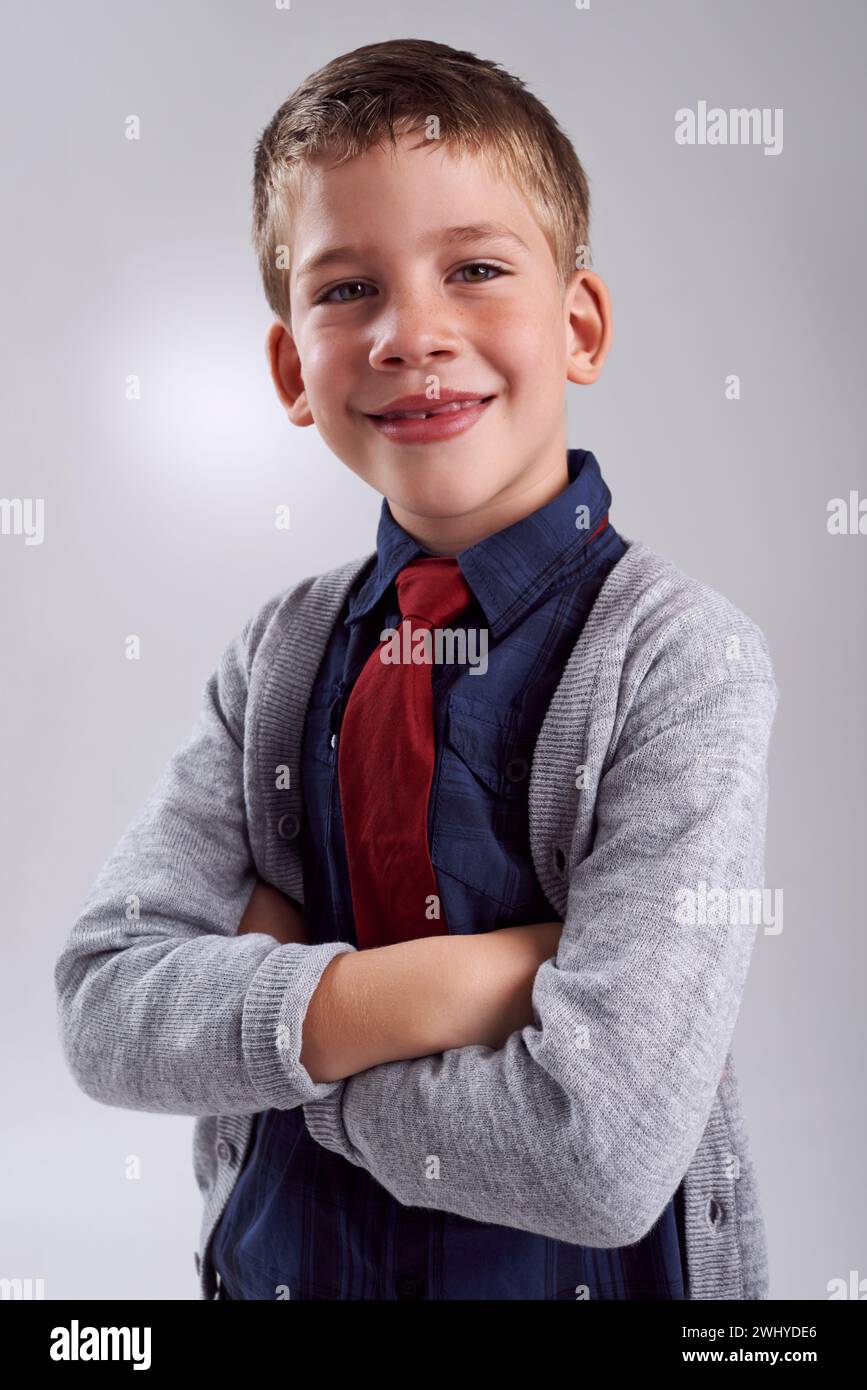 Smile, crossed arms and portrait of child in studio with classy ...