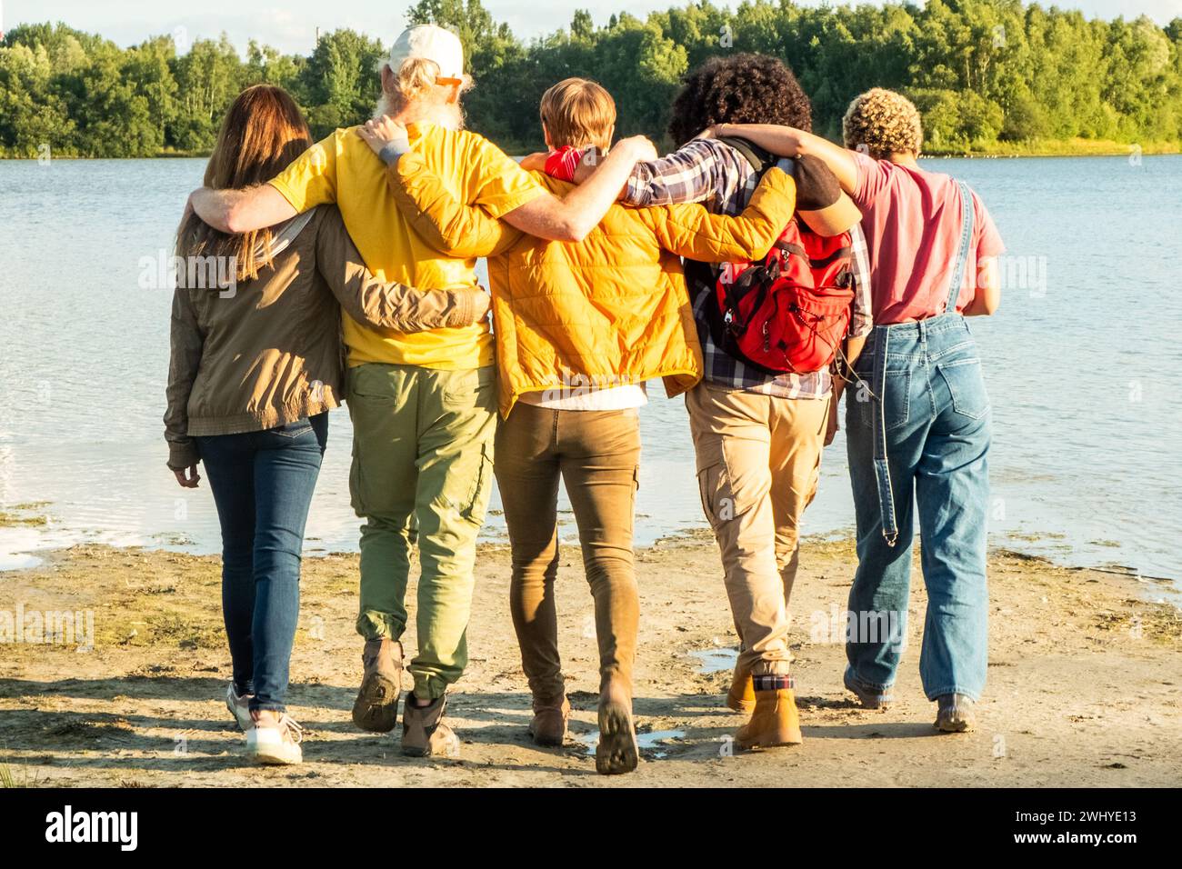 Wanderlust lifestyle, rear view of Friends Hugging by Forest Lake Stock ...