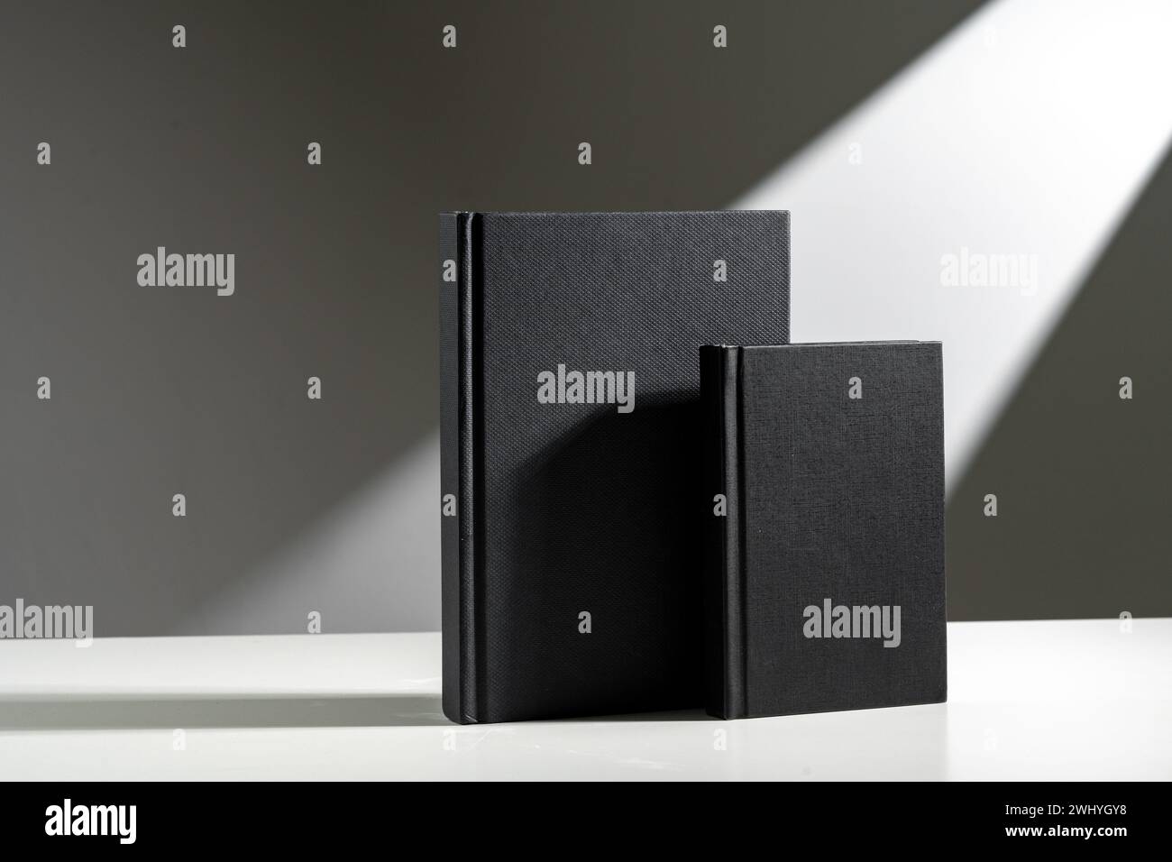 Black notepad in sunlight against gray background Stock Photo - Alamy