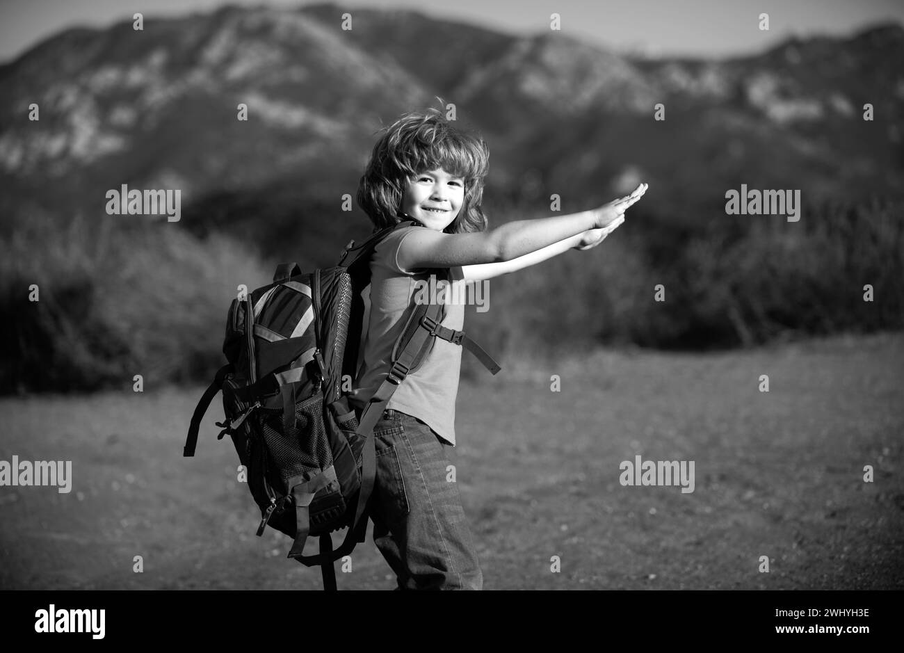 little kid with backpack hiking in scenic mountains. Child local ...