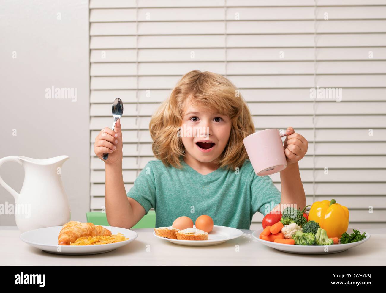 Schoolchild eating breakfast before school. Portrait of little teen ...