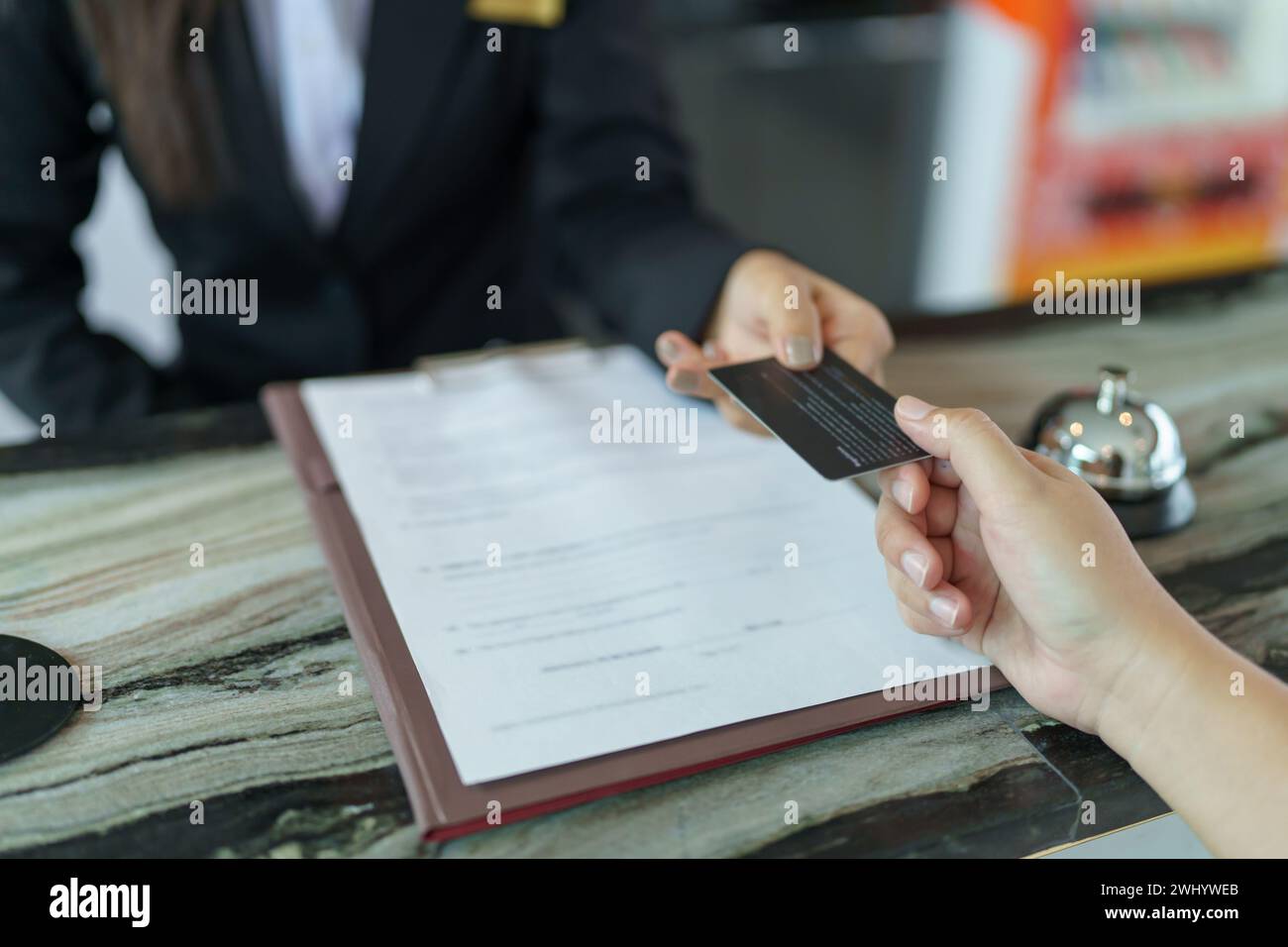 Hotel receptionist in uniforms Concierge giving the key doing ch Stock ...