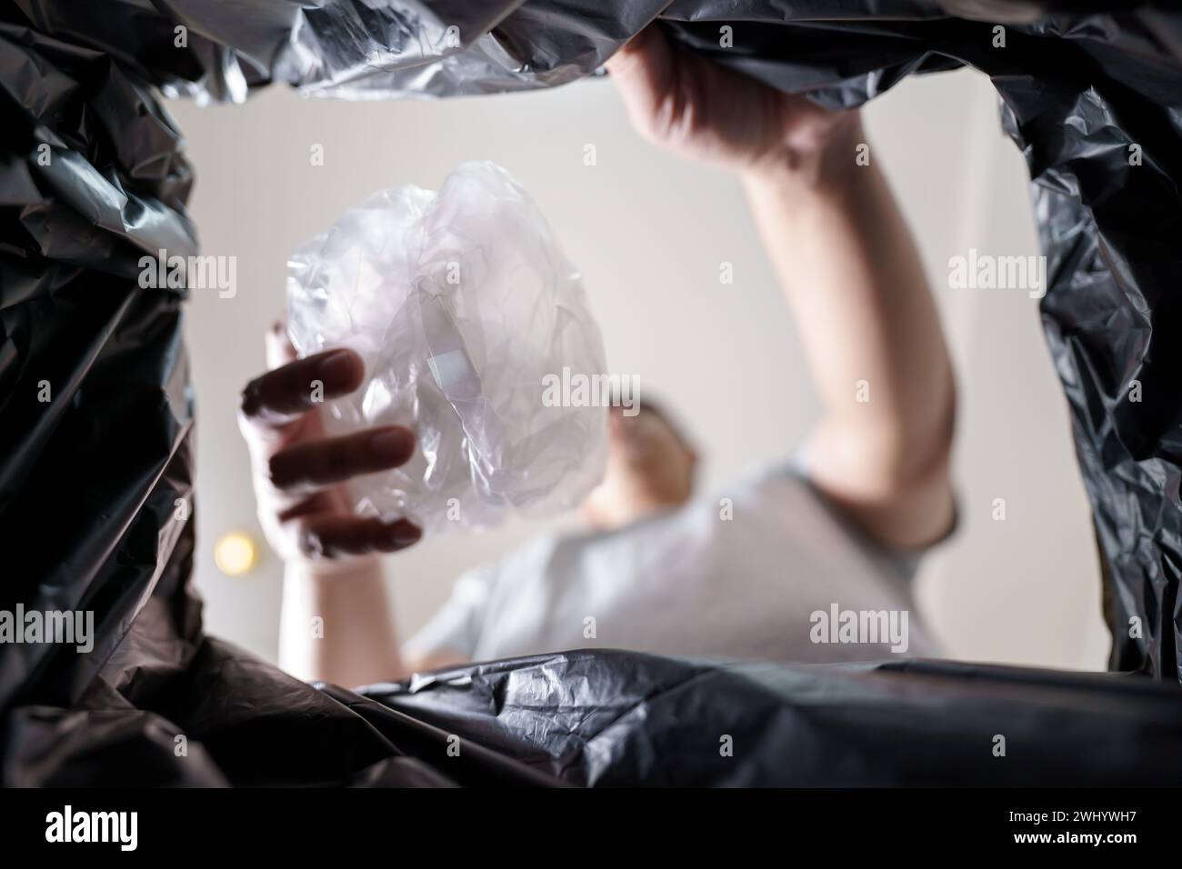 Image from inside yellow recycling bag of man throwing empty plastic ...