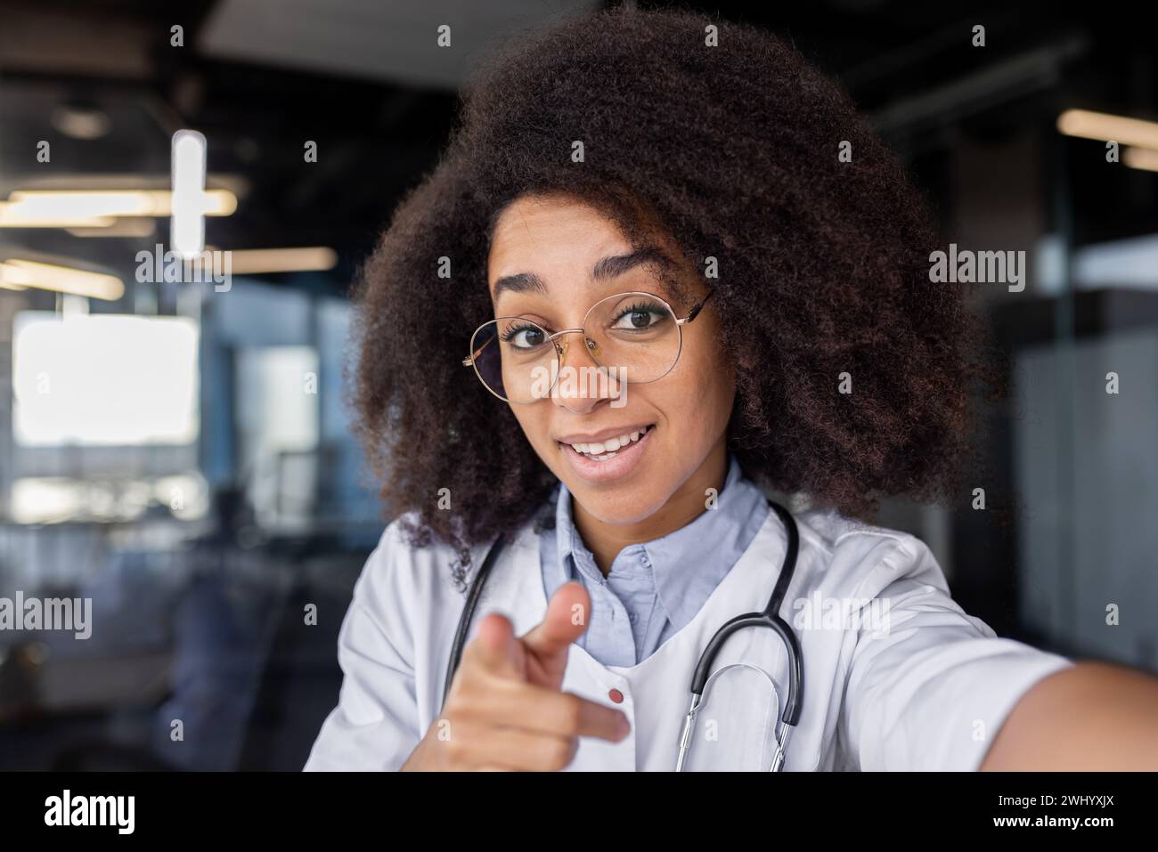 Diverse medic student in eyeglasses with bushy hairdo pointing at ...