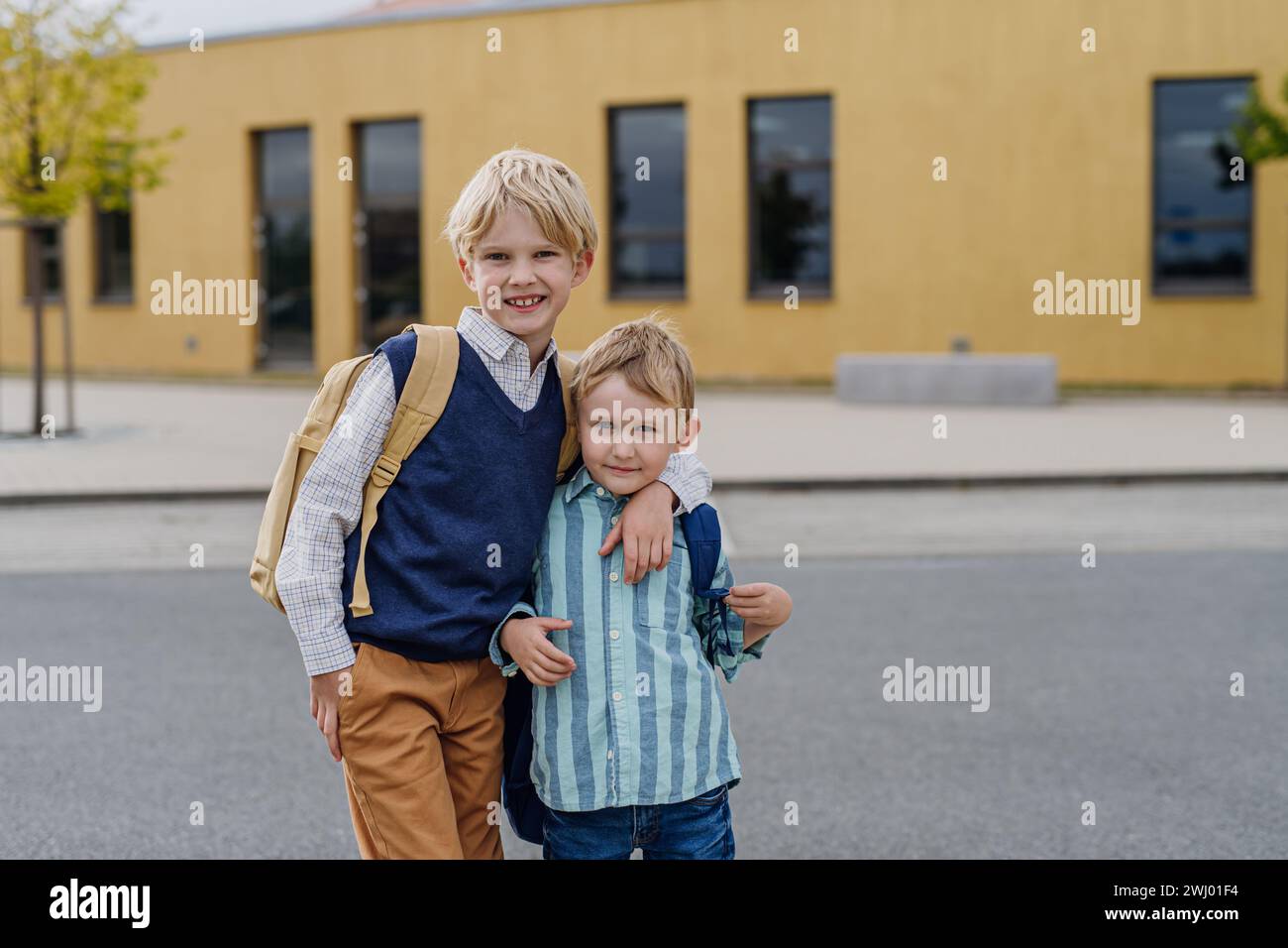 Portrait of two brothers in front of school building. Concept of work ...