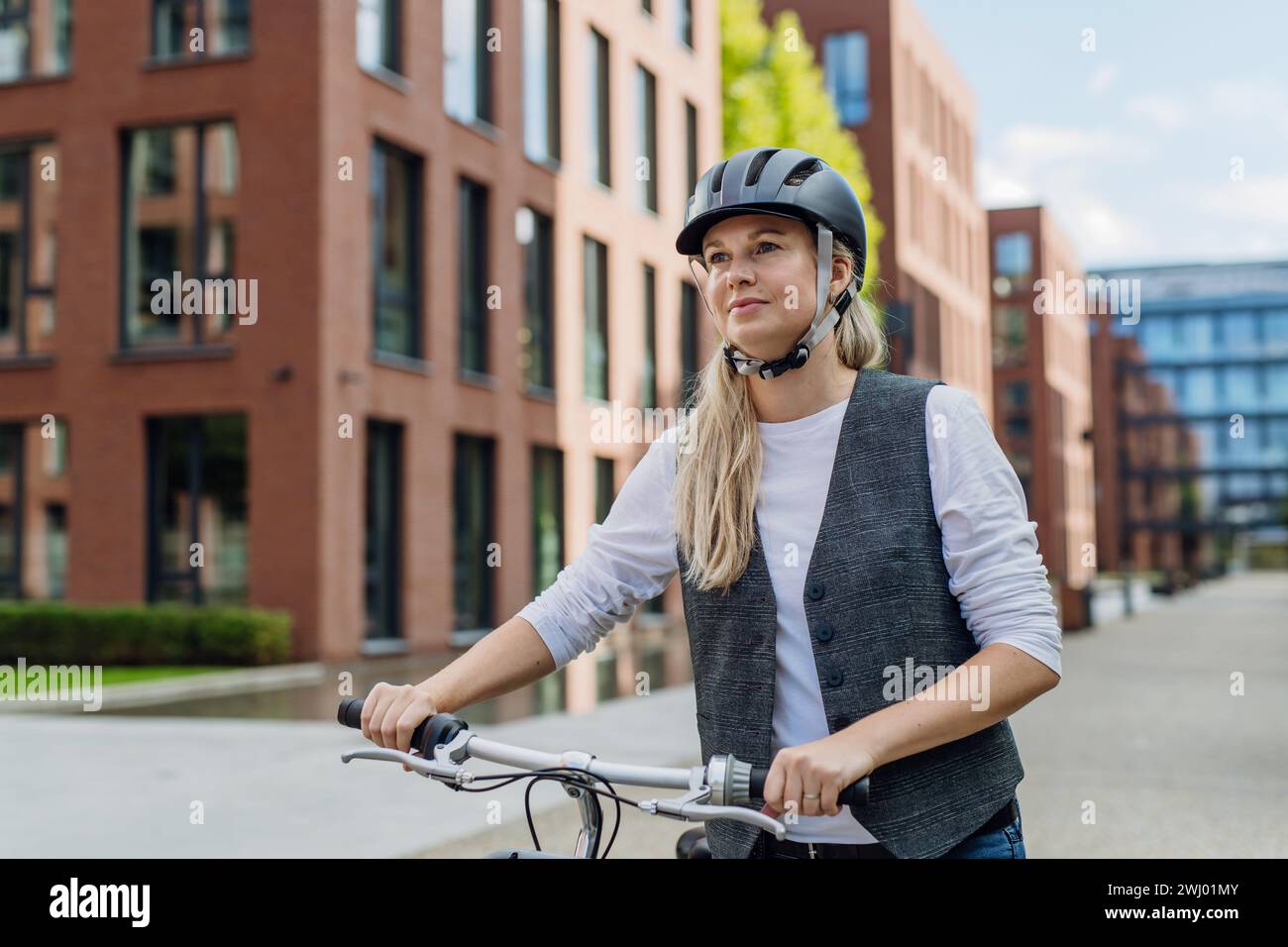 Beautiful middle-aged woman commuting through the city by bike. Female ...