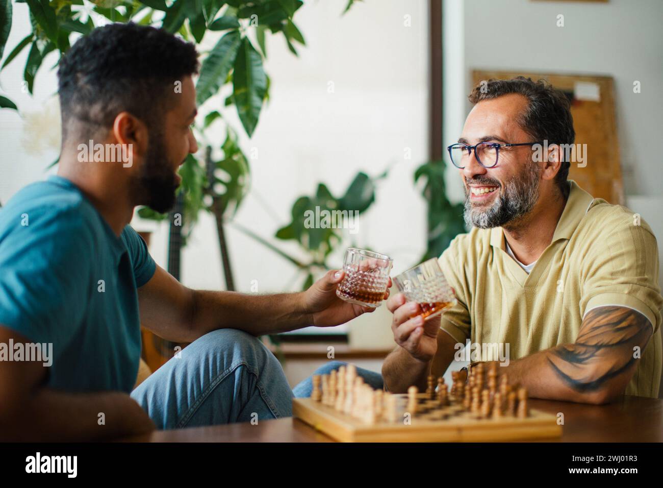 Best friends playing chess together, drinking whiskey and talking ...