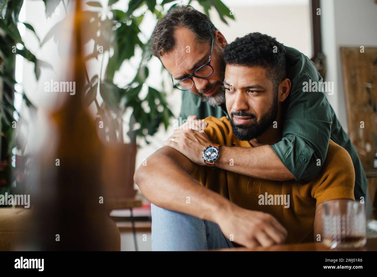 Man hugging best friend, supporting each other, drinking whiskey and ...