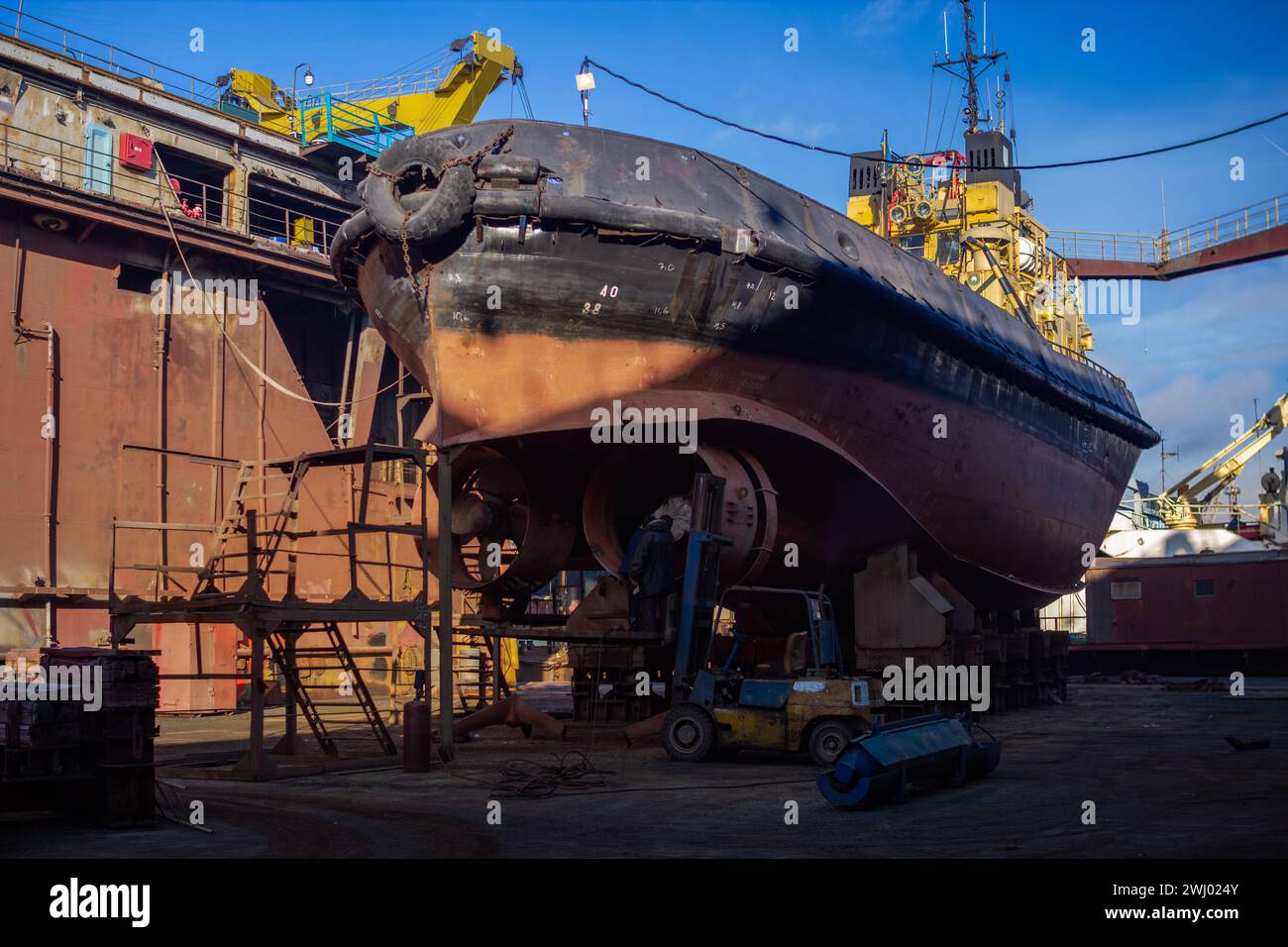 Industrial workers repair fishing boat in dry dock. Maintenance of ...
