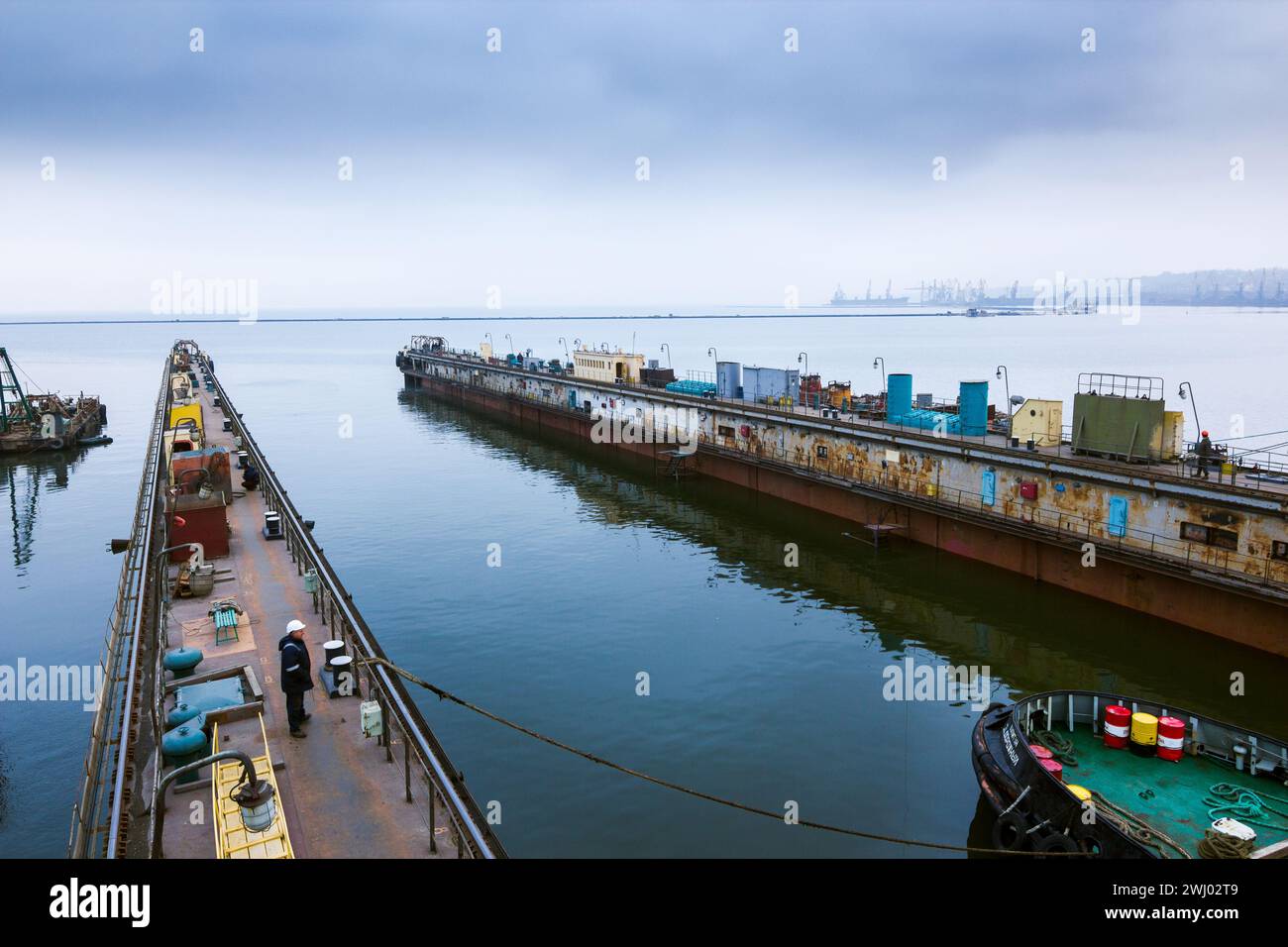 Vessel maneuvers into floating dock at maritime yard for repairs ...