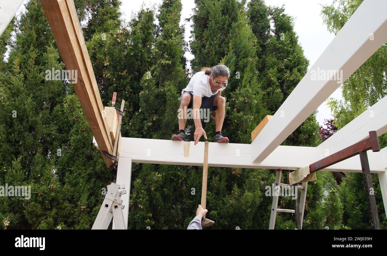 Balance over wooden construction. male worker standing on wood beams ...