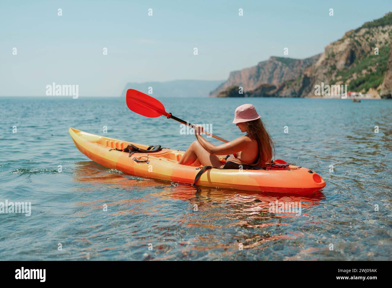 Kayak sea woman. Happy attractive woman with long hair in red swimsuit ...