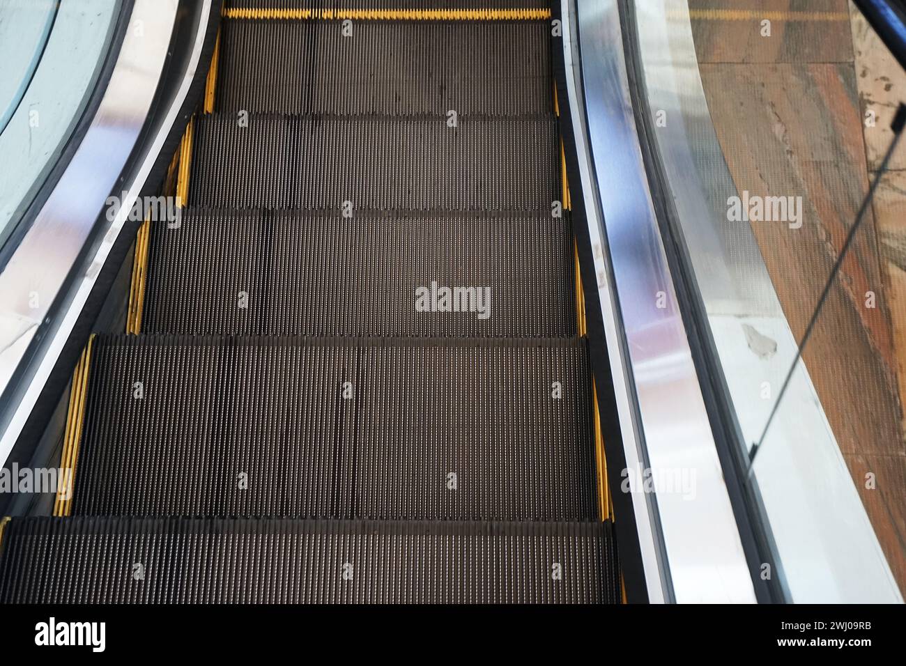 Automatic escalator moving down staircase Stock Photo - Alamy