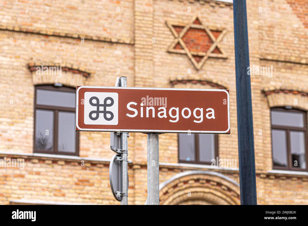 Old brick Synagogue, Jewish shul or temple with road signpost and David ...