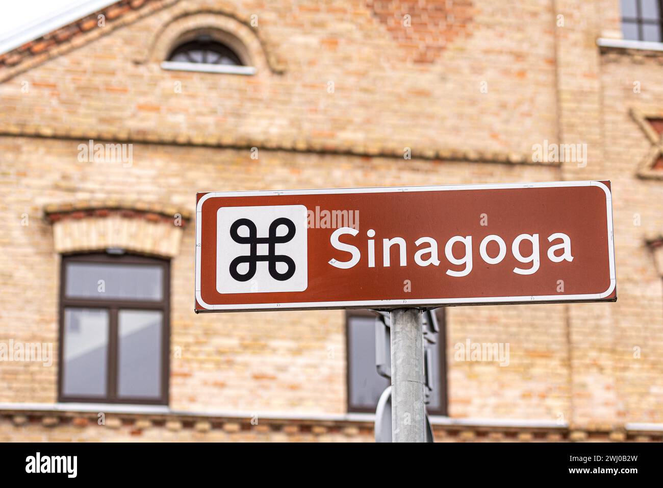 Old brick Synagogue, Jewish shul or temple with road signpost and David ...