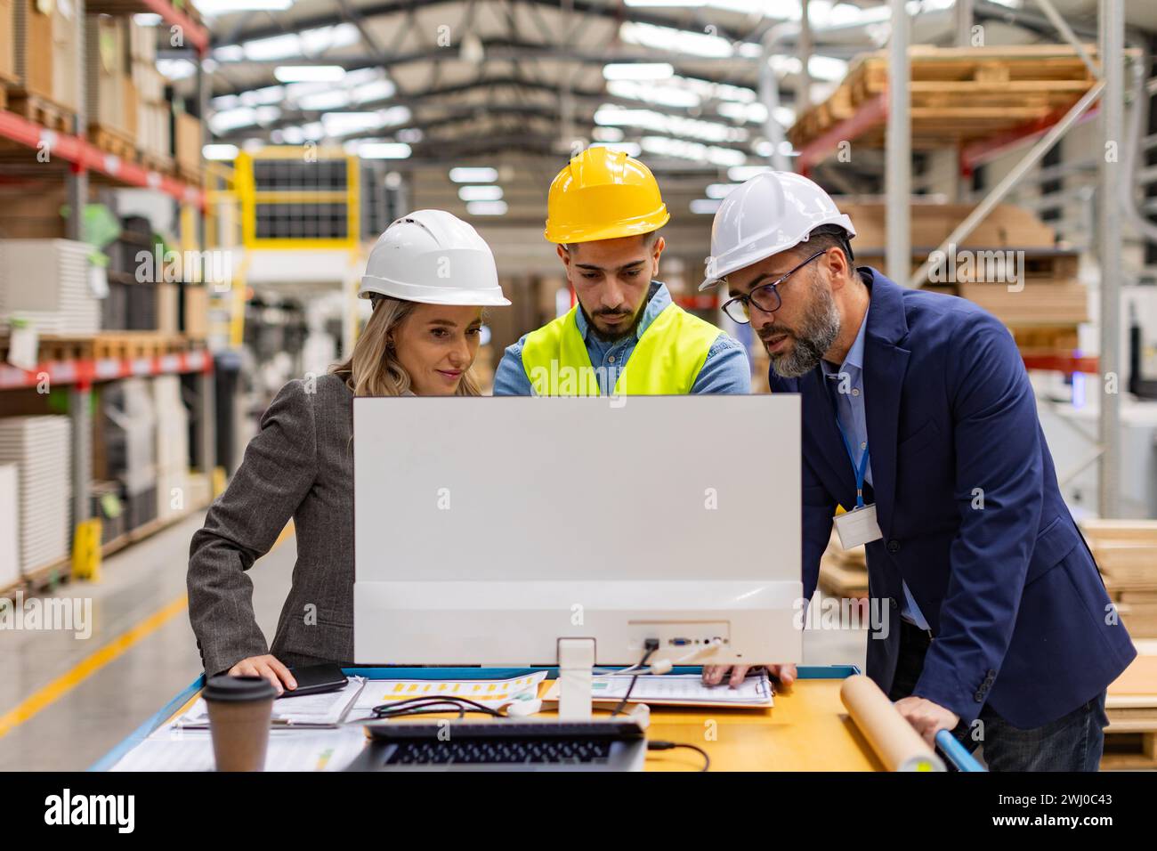 Engineer, foreman consulting with director in modern industrial factory ...