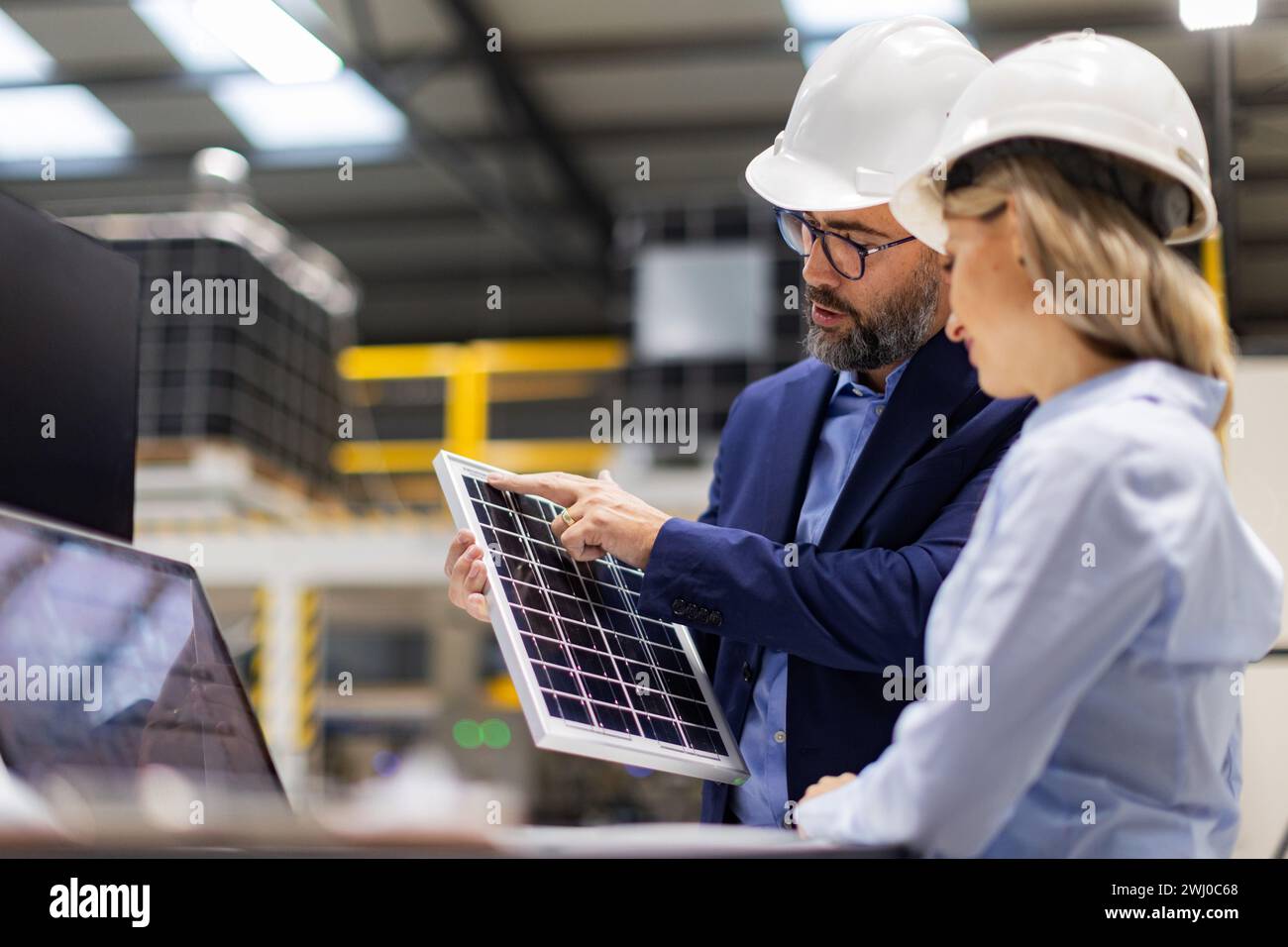 Female engineer and male director talking in modern industrial factory ...