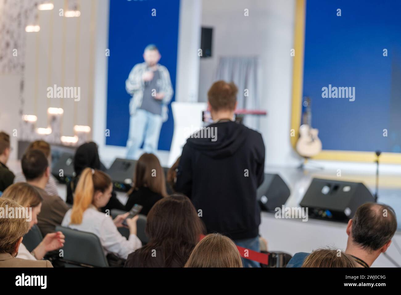 Blurred view of an engaging speaker at a conference with an attentive ...