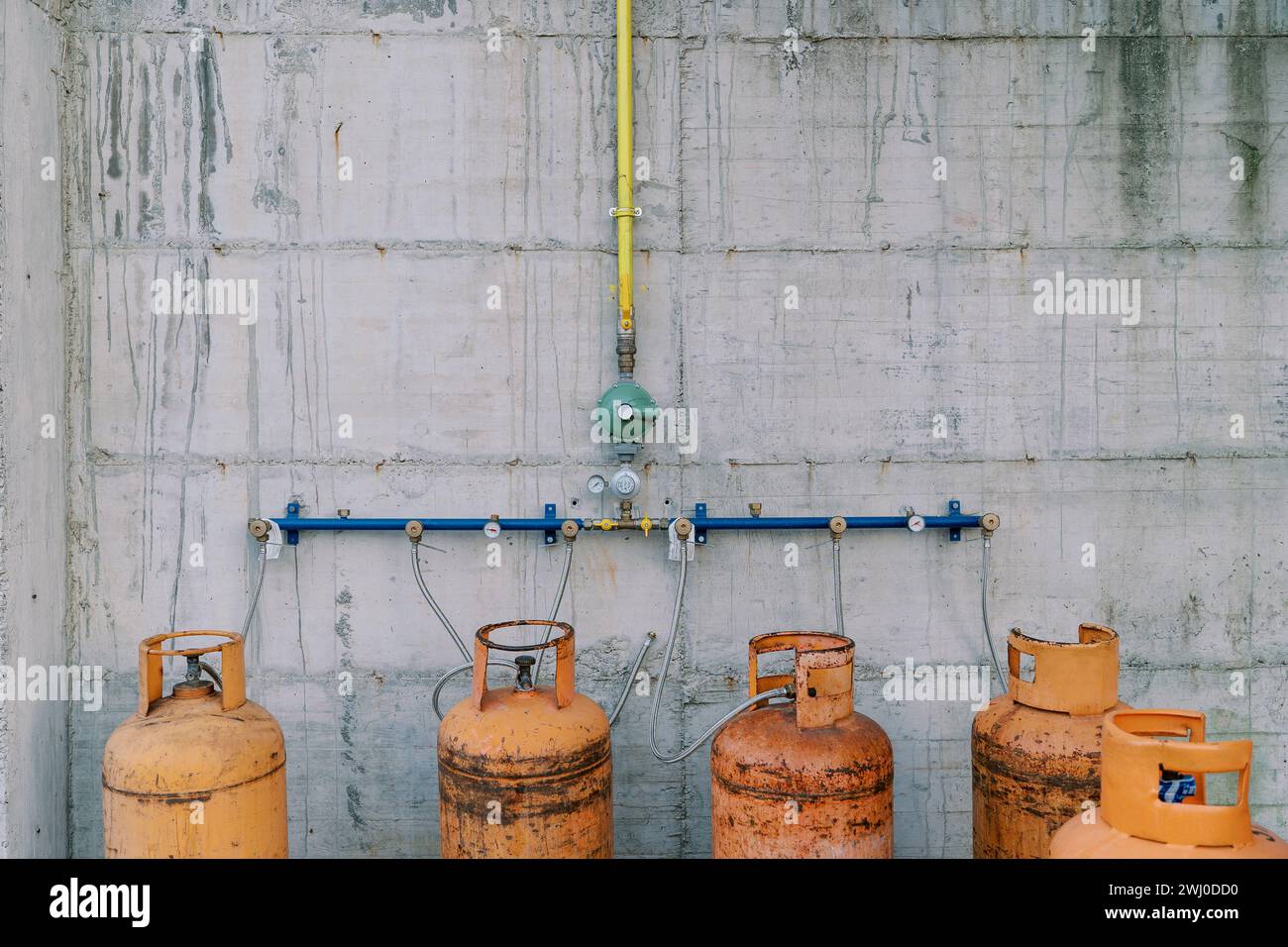 Gas cylinders connected to pipes on a concrete wall Stock Photo - Alamy