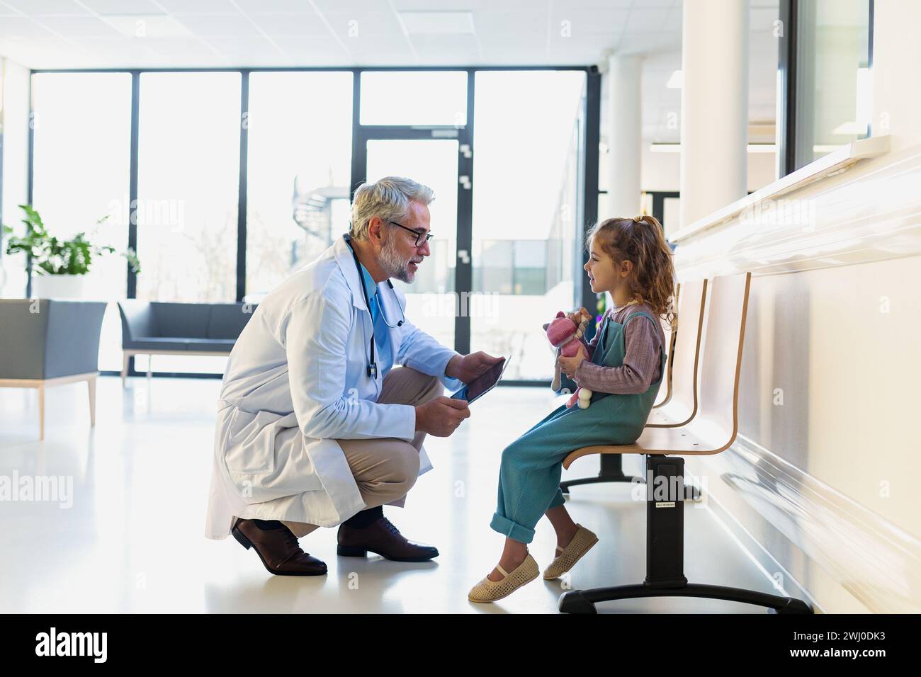 Friendly pediatrician talking to little patient. Cute preschool girl in ...