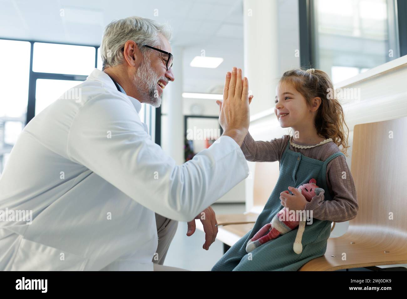 Friendly pediatrician giving high five to little patient. Cute ...