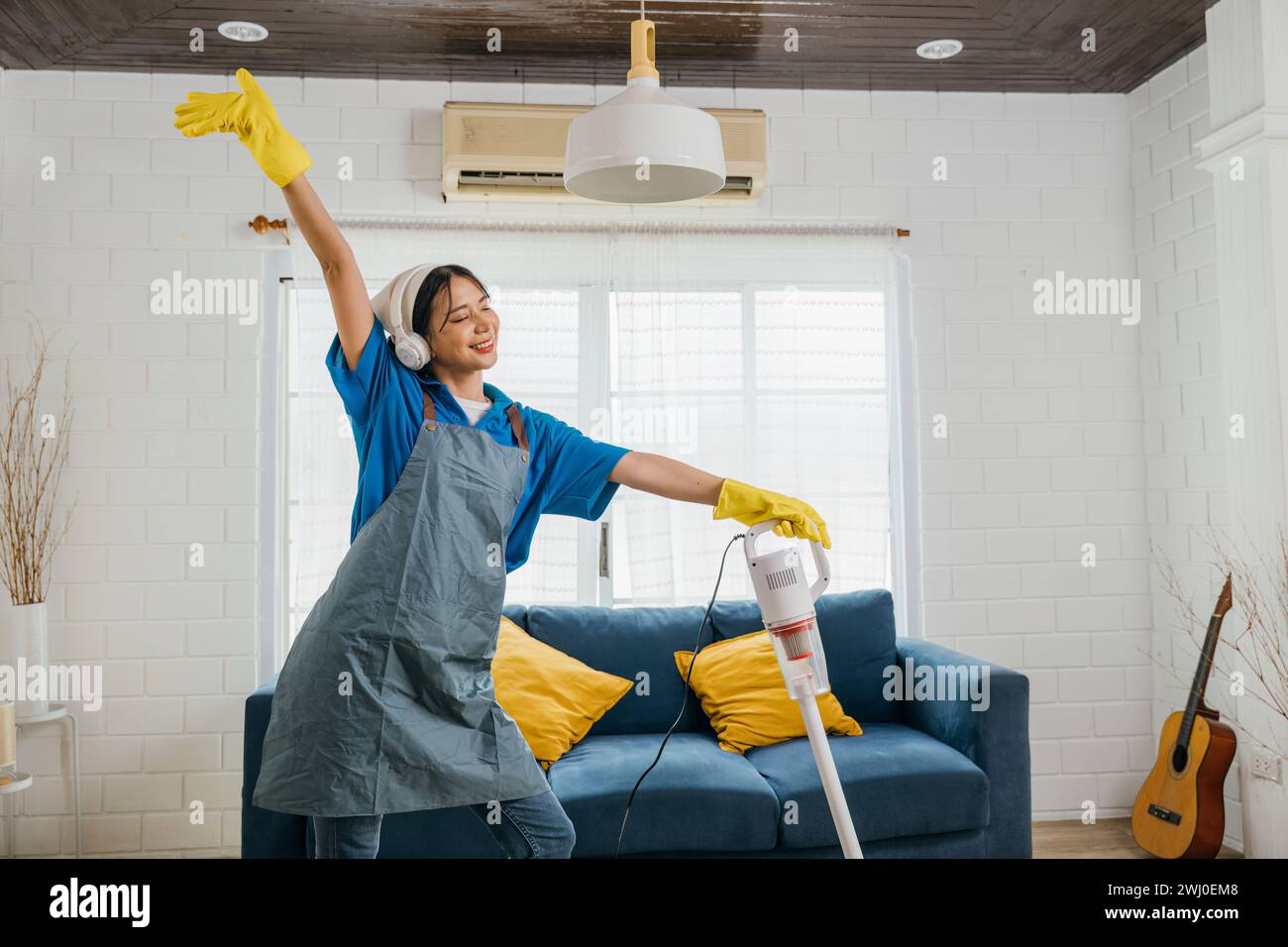 Energetic maid's cleanup melody, Asian woman uses mop as mic singing ...
