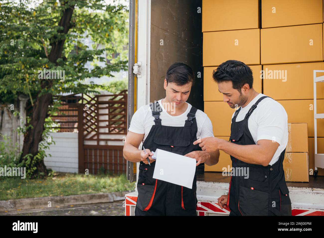 Colleague documents as delivery man unloads boxes from the truck ...