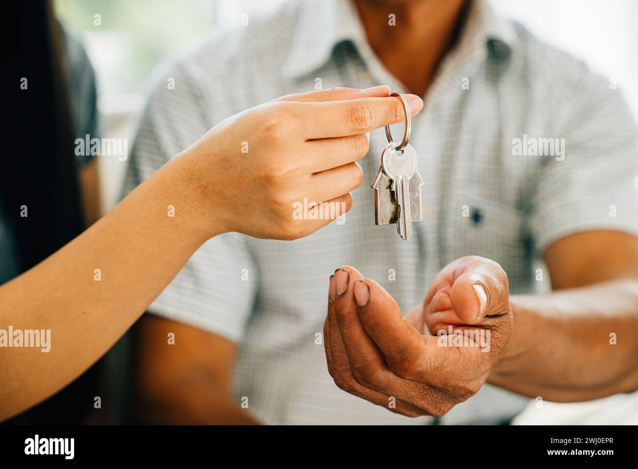 A delighted couple celebrates new homeownership displaying keys to ...