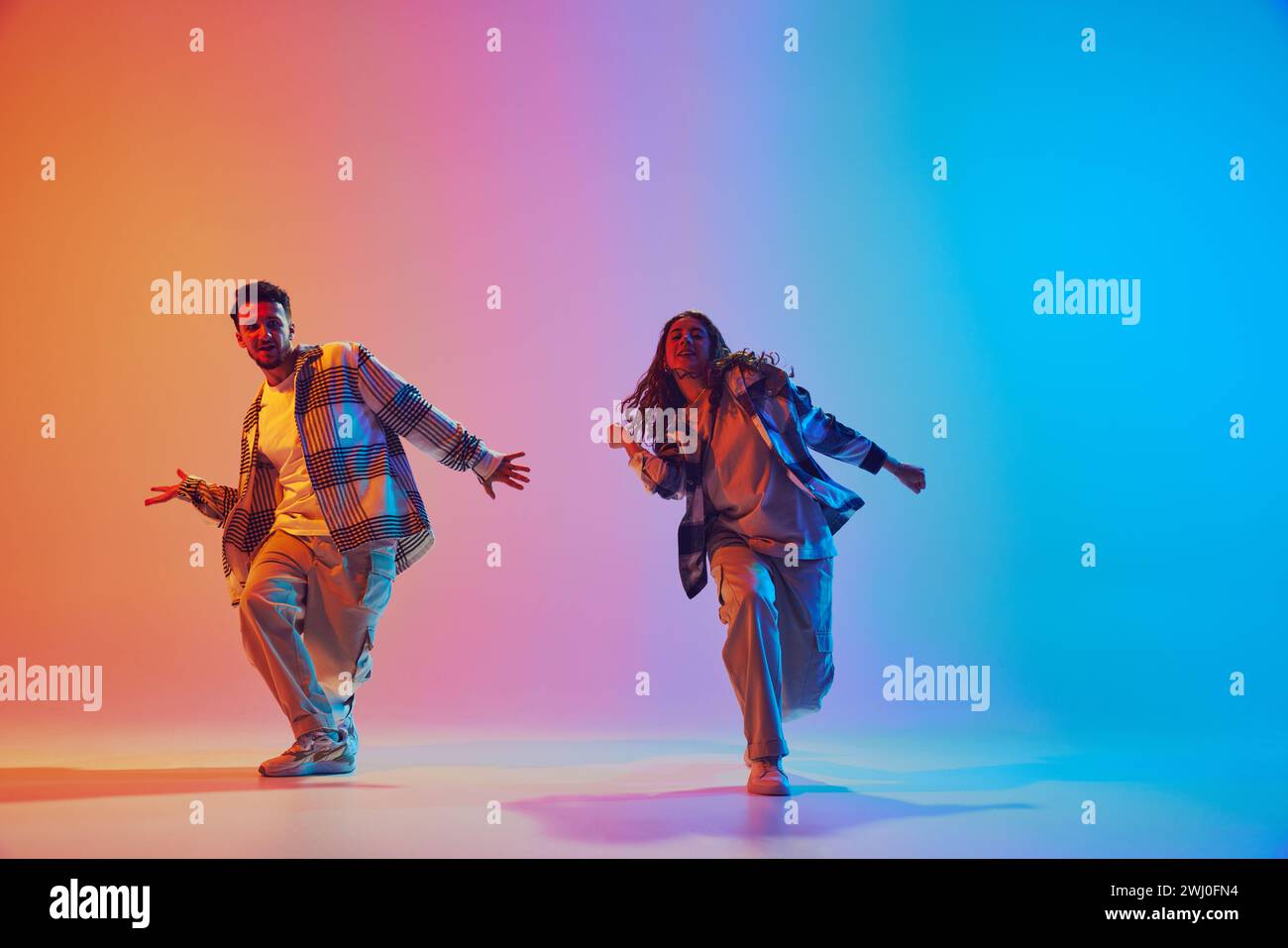 Dynamic duo, man and woman, mid-dance in vibrant neon against gradient ...