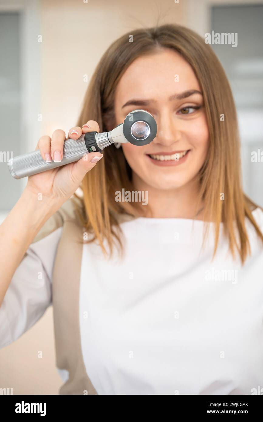 Portrait of woman dermatologist with dermatoscope in uniform and gloves ...